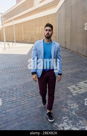 Young bearded man, model of fashion, sitting in an urban step wearing ...