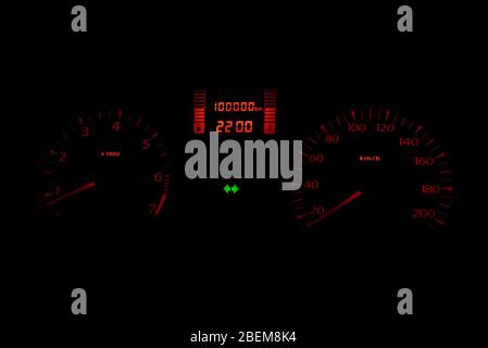 Black automobile dashboard with orange lights of odometer and green ...