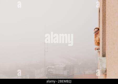 Quarantined woman bending over the window watching outside Stock Photo ...