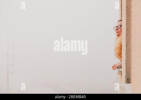 Quarantined woman bending over the window watching outside Stock Photo ...