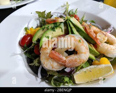 Appetizing shrimp and avocado salad served in black textured bowl ...
