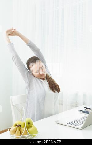 Tired woman stretches back and arms after finishing report Stock Photo ...