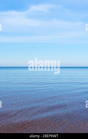 selective focus, flat horizon line, blue lake with cloudy sky in the ...