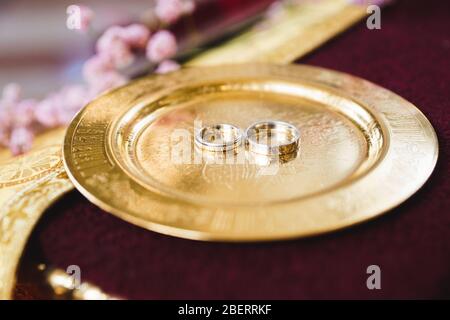 Wedding rings on golden platter in church Stock Photo - Alamy