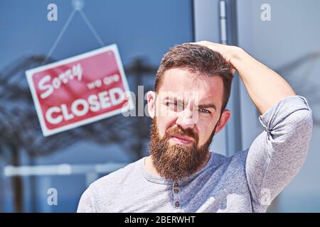 Bemused beggar man near closed-door of office. Unemployment during ...