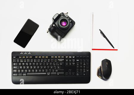 Office desk with supplies, photo camera and coffee over black leather ...