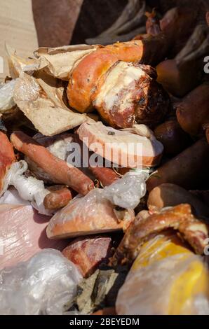Spoiled sausages close-up. Various unsuitable foods in a trash can ...