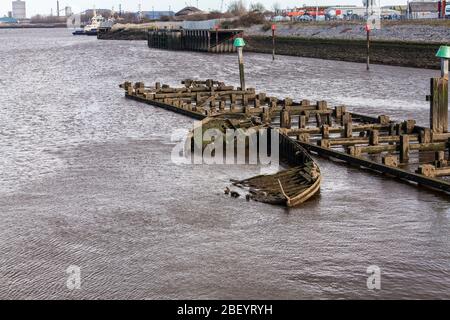 A sunken rowing boat and a wooden jetty in the River Tees at ...