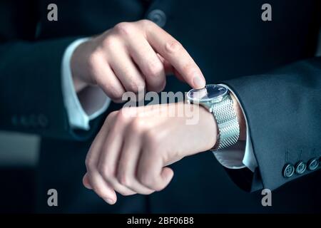 Businessman looking at watch Stock Photo - Alamy