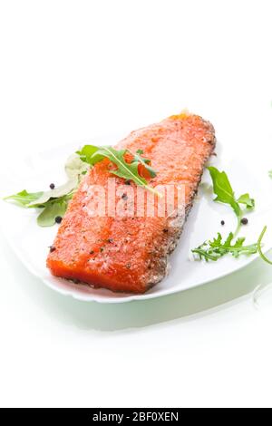 piece of salty red fish with different seasonings and herbs in a plate ...