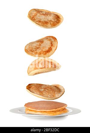 Tasty fresh pancakes falling on beige background Stock Photo - Alamy