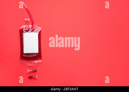 Blood pack for transfusion, test tubes and paper drops on pink ...