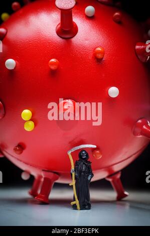 Grim reaper with red coronavirus model metaphor Stock Photo - Alamy