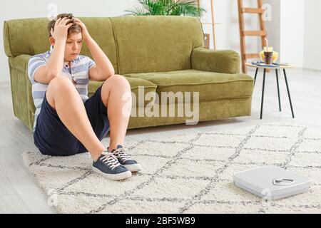 sad fat boy is upset after losing a video game, sit closing face, alone ...