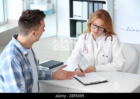 Young man visiting female cardiologist in clinic Stock Photo - Alamy