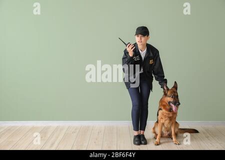 Female police officer with dog near color wall Stock Photo - Alamy