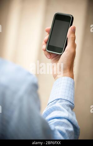 Holding mobile phone, over shoulder view of man hand holding mobile ...