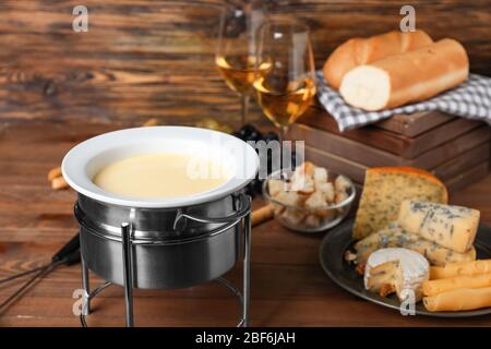 Cheese fondue with snacks on wooden background Stock Photo - Alamy