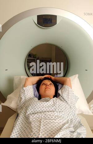 A Siemens CT scanner A patient lies on the examination table of a ...