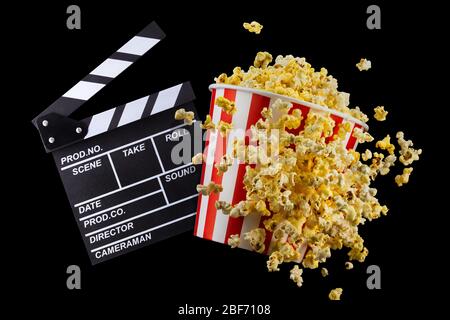 Flying popcorn and film clapper board isolated on white background ...