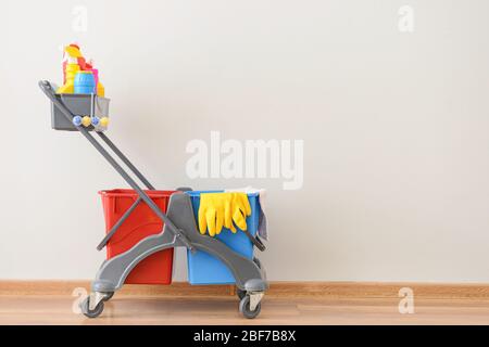 Set of cleaning supplies near white wall Stock Photo - Alamy