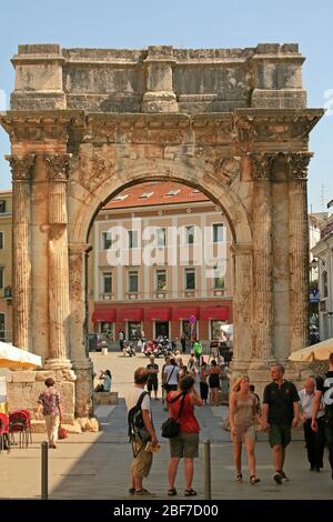 Pedestrians passing through the "Golden Gate" of Pula. Known as the ...