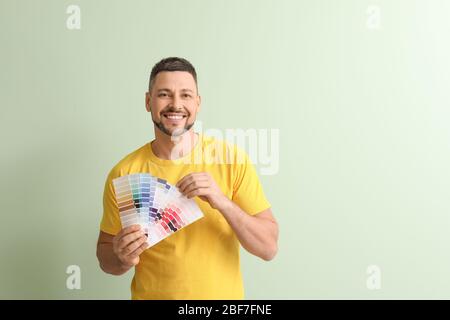 Man with color palettes on green background Stock Photo - Alamy
