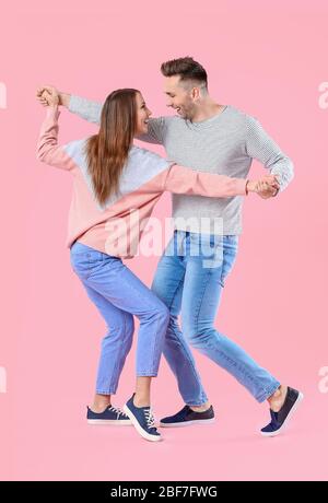 Happy couple dancing against color background Stock Photo - Alamy