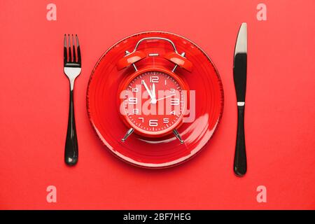 Alarm clock and cutlery on color background. Diet concept Stock Photo ...