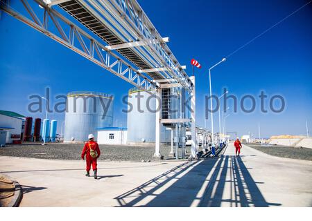 chemical industry plant - workers in work clothes in a refinery with ...