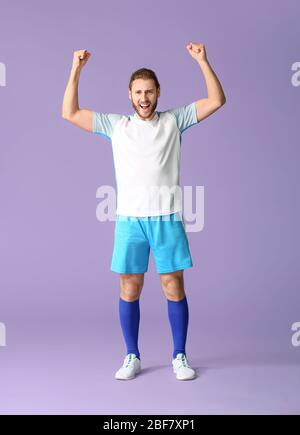Happy football player on color background Stock Photo - Alamy