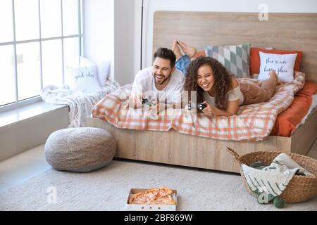 Young woman with tasty pizza playing video game at home Stock Photo - Alamy