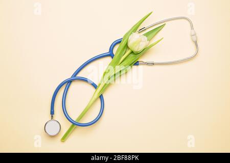 Medical stethoscope with flower on light wooden background Stock Photo ...