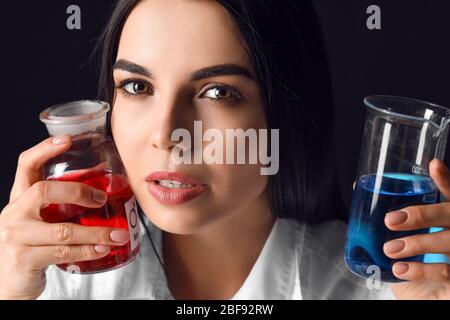 Female alchemist with potions on dark background Stock Photo - Alamy