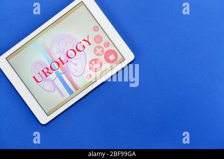 Tablet computer with picture of urogenital system on screen and urine ...