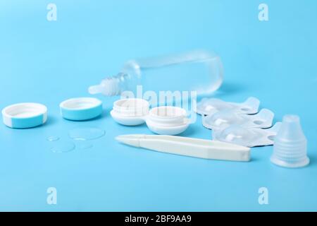 Containers with contact lenses, solution and tweezers on color ...