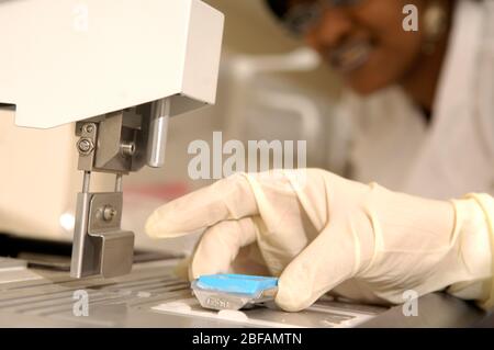 Laboratory students load a microscopic slide into a microscope.(MODEL ...