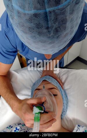 Anaesthesia. Anaesthetist administering gas to a patient. The gas is a ...