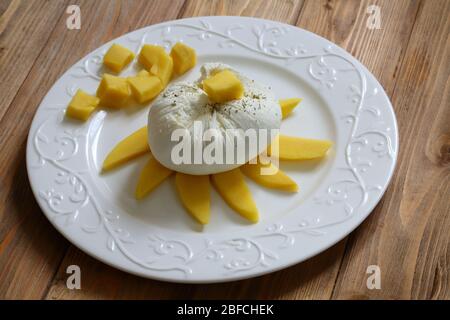 Soft white cheese with mango, walnut and honey Stock Photo - Alamy
