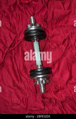 Dumbbell with red weights on a black weight training bench ready to use ...