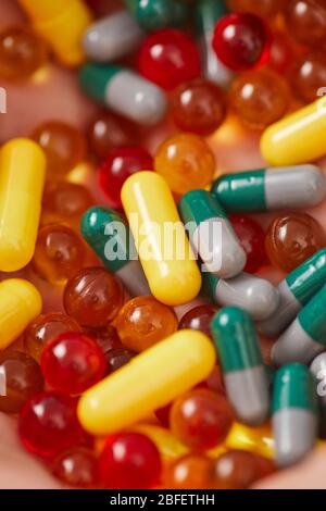 Macro shot of multi-colored pills and capsules heap on a blue ...