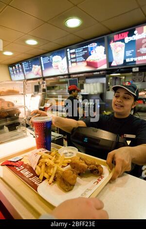 A KFC employee serving a hungry customer in the restaurant on Oxford ...
