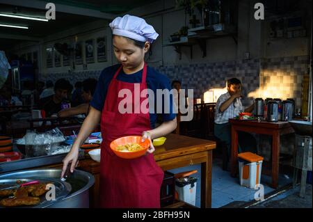 Women preparing food at a roadside restaurant at the Hua Hin night ...