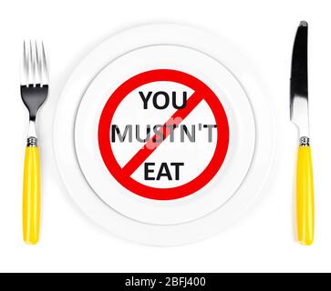 Plate with text "You mustn't eat", fork and knife isolated on white ...