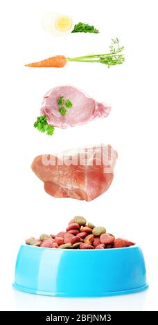 Concept of food for pets. Food falling in pet's bowl isolated on white ...