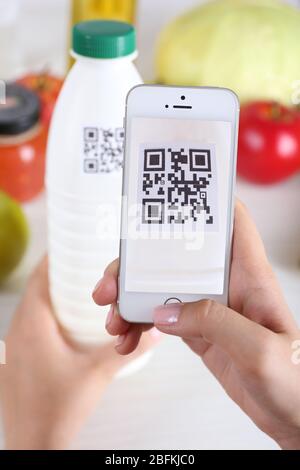 Woman scanning voucher code with mobile phone close up Stock Photo - Alamy