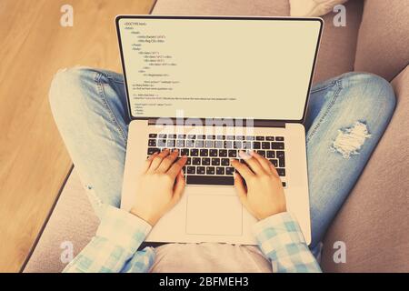 Programmer woman writing program HTML code sitting at workplace in office, IT software developer ...
