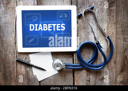Medical tablet and text Diabetes on screen on wooden table Stock Photo ...