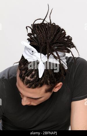 Stylish male model with afro braids posing in studio on isolated ...