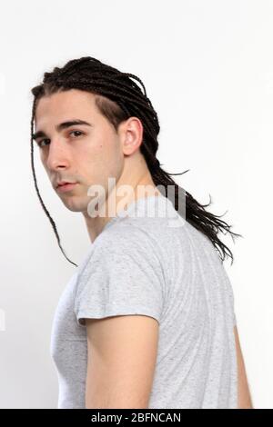 Stylish male model with afro braids posing in studio on isolated ...
